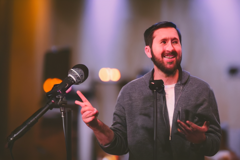 Stable Diffusion prompt: 32-year-old man on stage speakin...